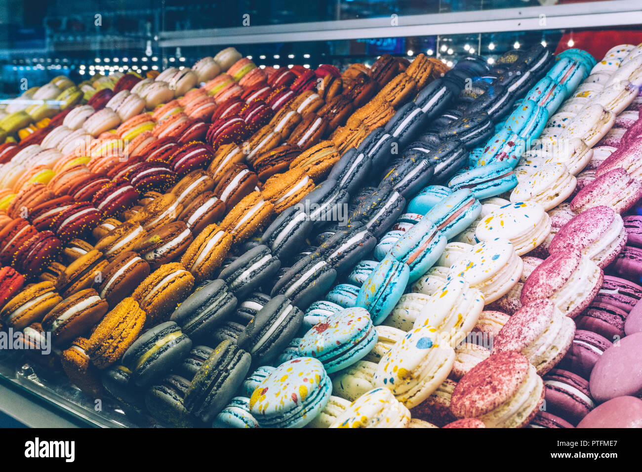 A lot of multicolored macarons (French macaroons) on the candy shop or ...