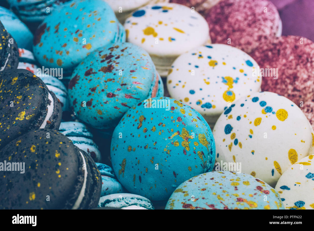 A lot of multicolored macarons (French macaroons) on the candy shop or ...