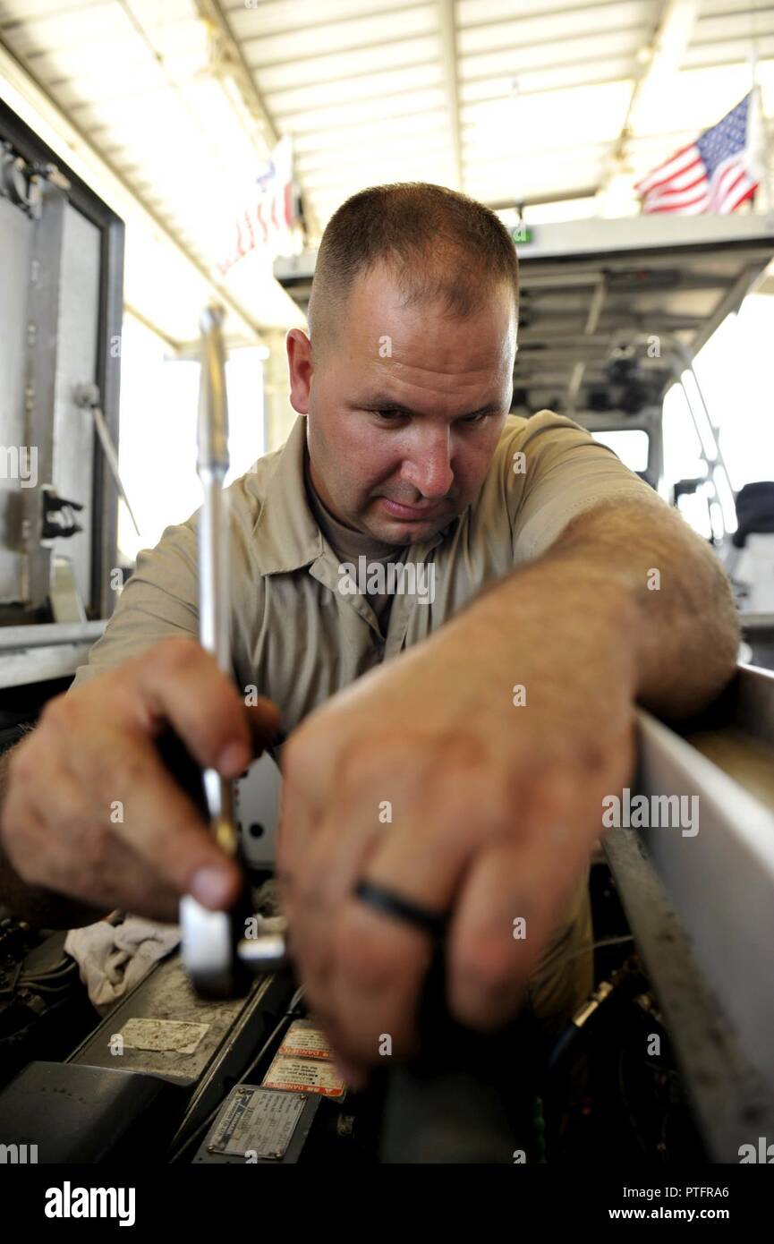 A Coast Guardsman with Port Security Unit 305 services an engine on a ...