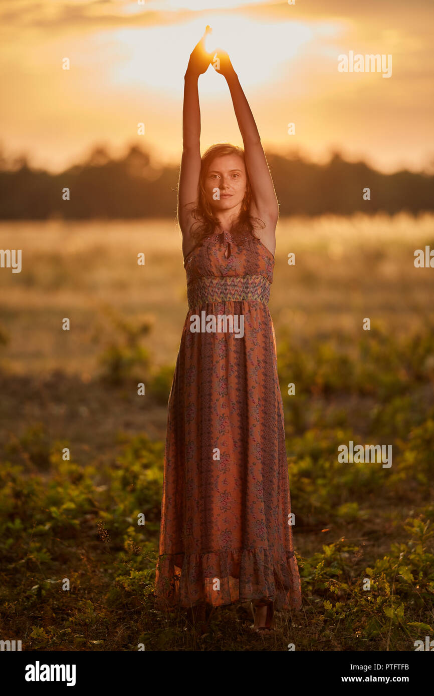 Portrait of a beautiful young woman in retro dress in the sunset at ...