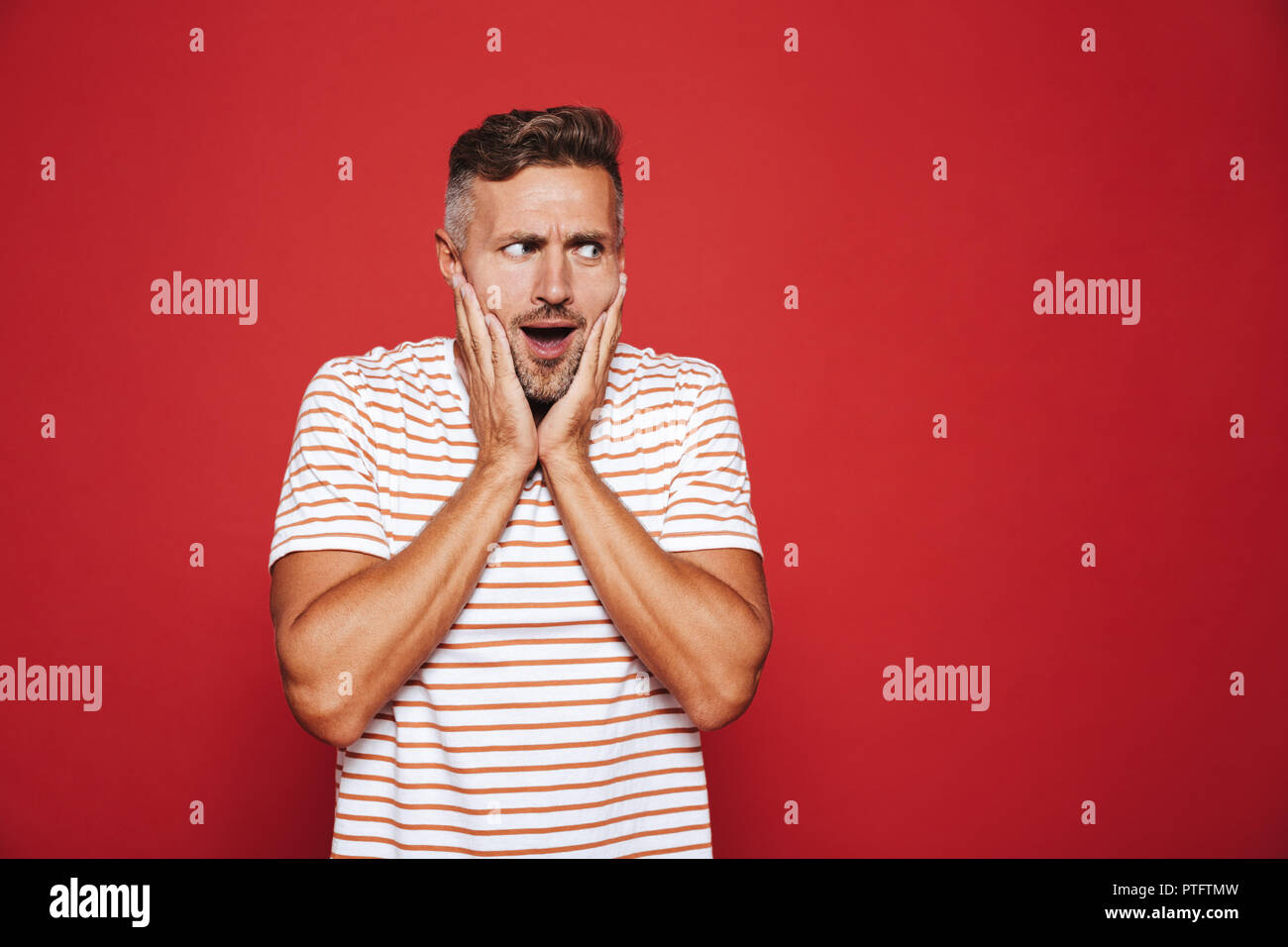 Portrait of terrified adult man grabbing his face in confusion or ...