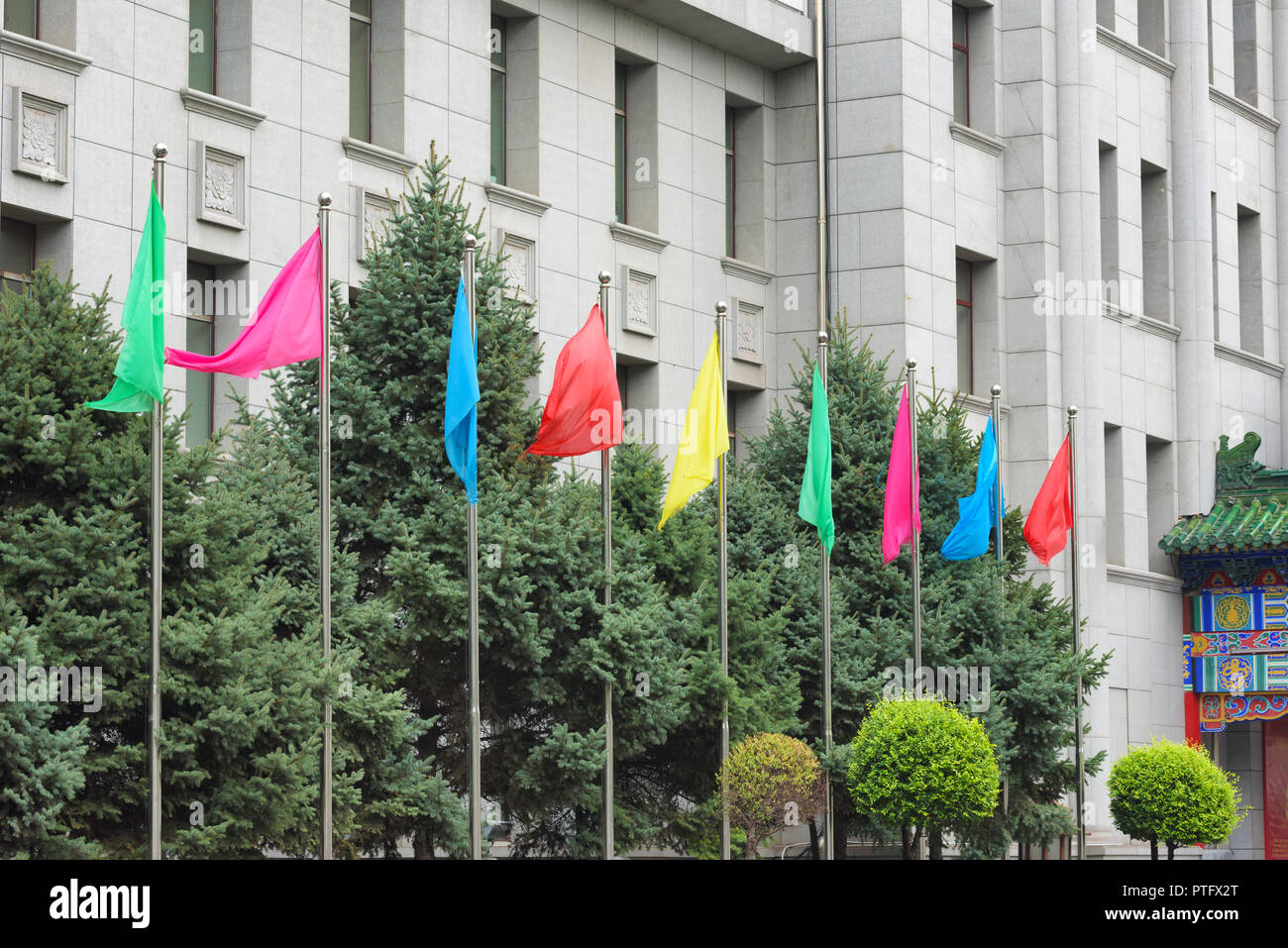 Colorful flags. Building facade and flags. Flagpoles Stock Photo - Alamy