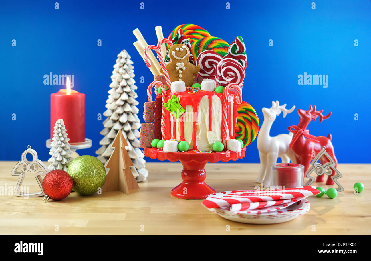 On trend festive candyland Christmas drip cake on blue background Stock ...