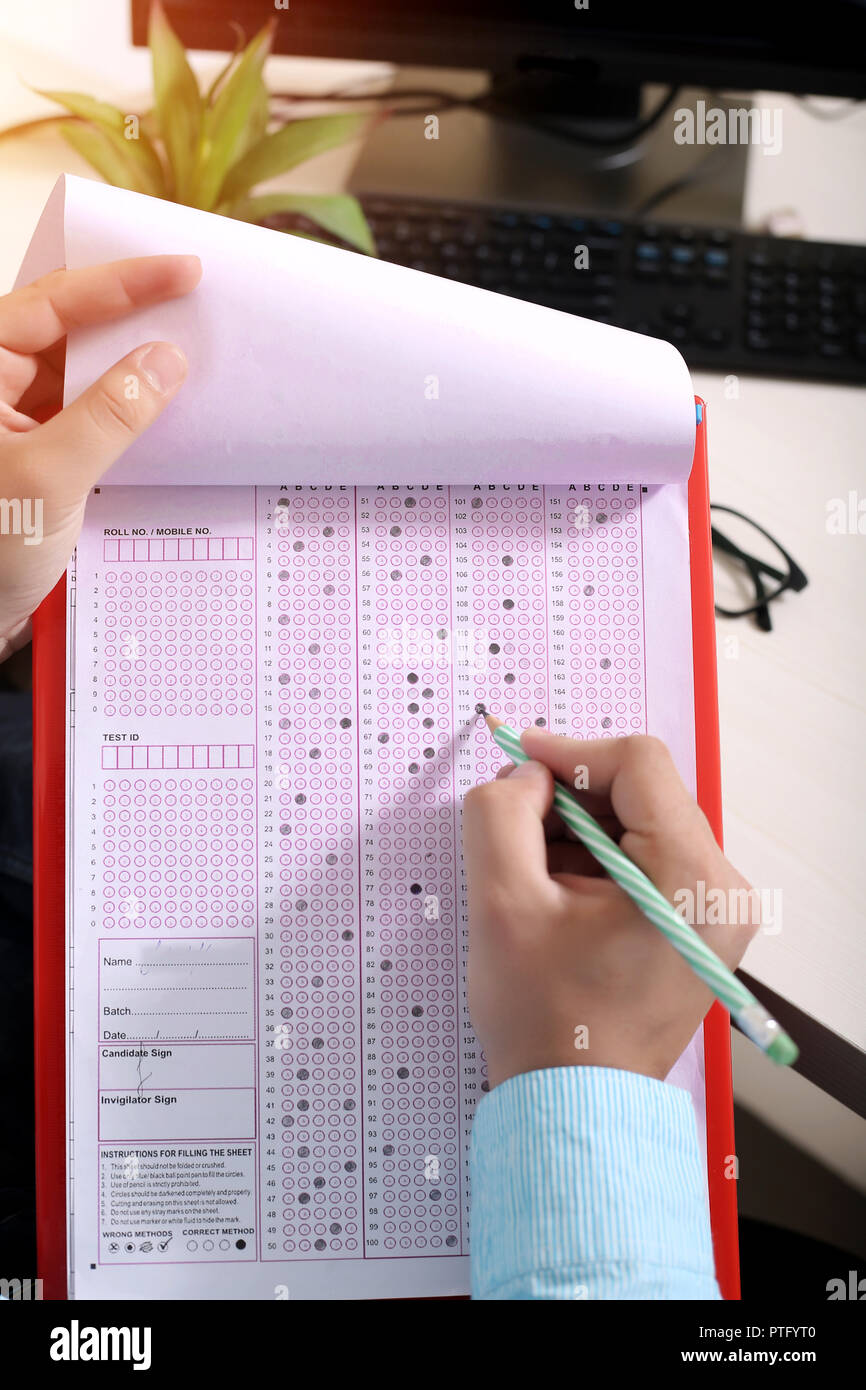 Man is filling OMR sheet with pencil. Picture of OMR sheet on the ...