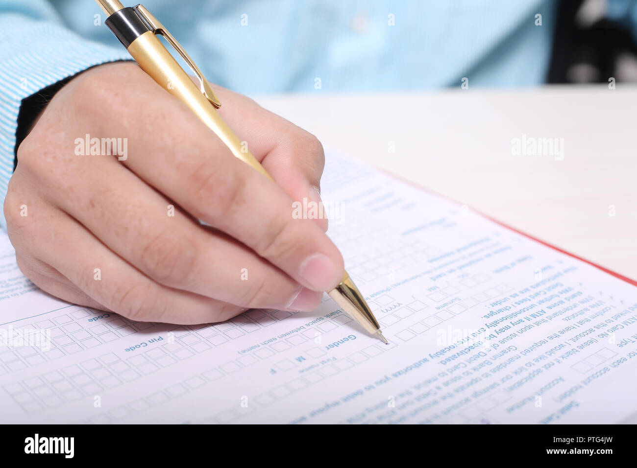 Man is filling form with pen Stock Photo - Alamy
