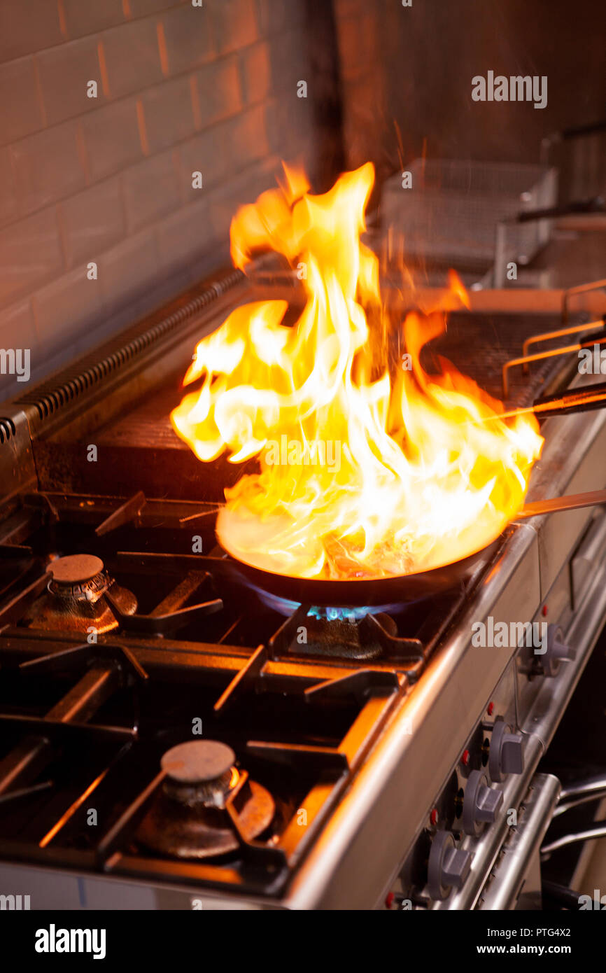 Chef cooking with high fire in kitchen restaurant Stock Photo - Alamy