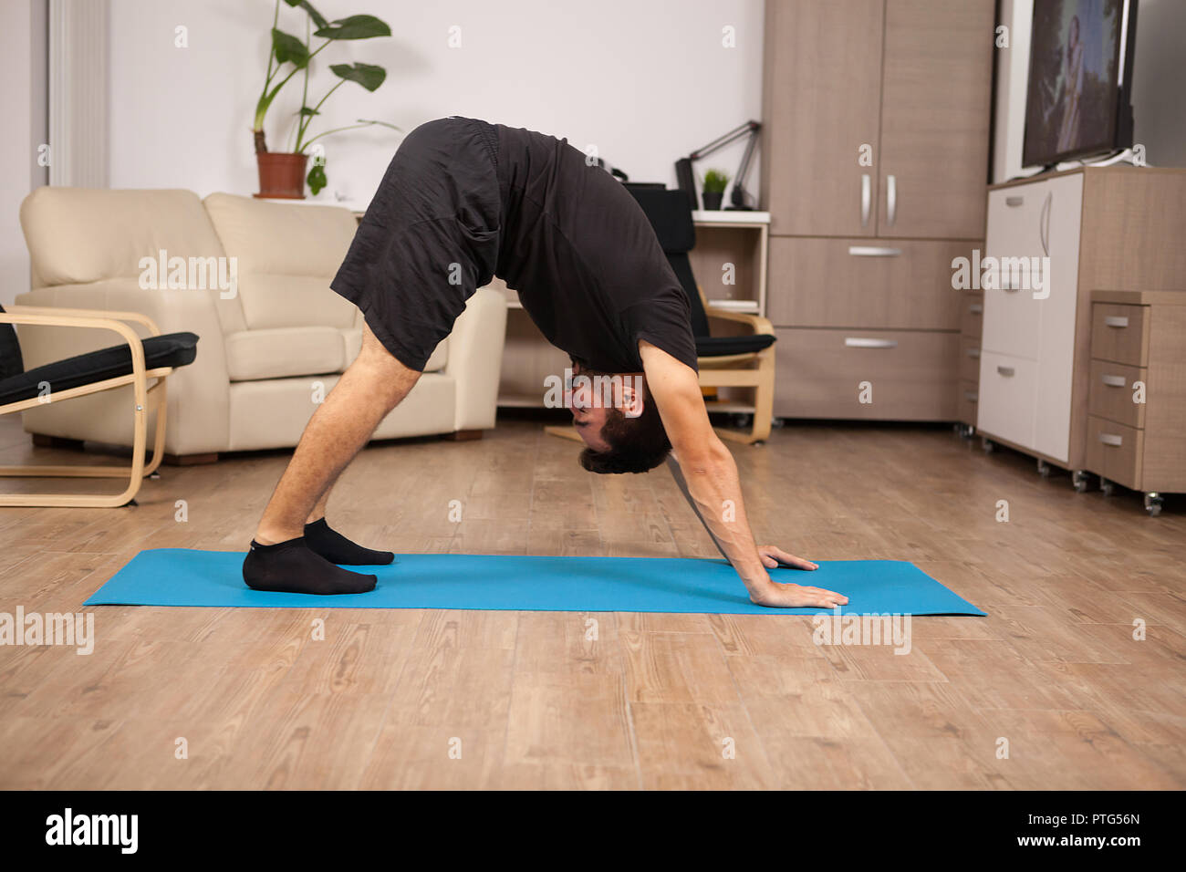 Adult man doing Dolphin yoga pose in his workout routine. Healthy ...