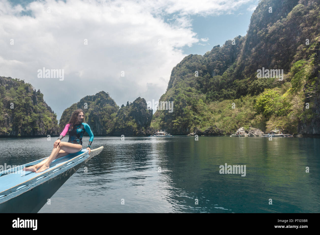 Woman relaxing on the boat and looking forward into lagoon. Travelling ...