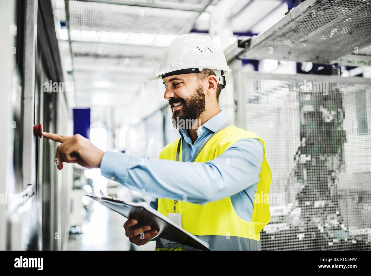 A portrait of an industrial man engineer with clipboard in a factory ...