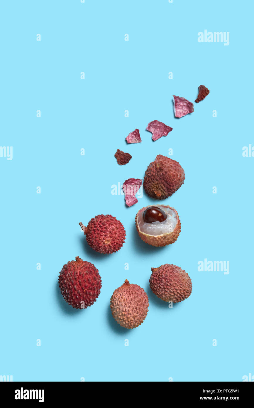 The composition of lychee and peel on a blue background with copy space ...