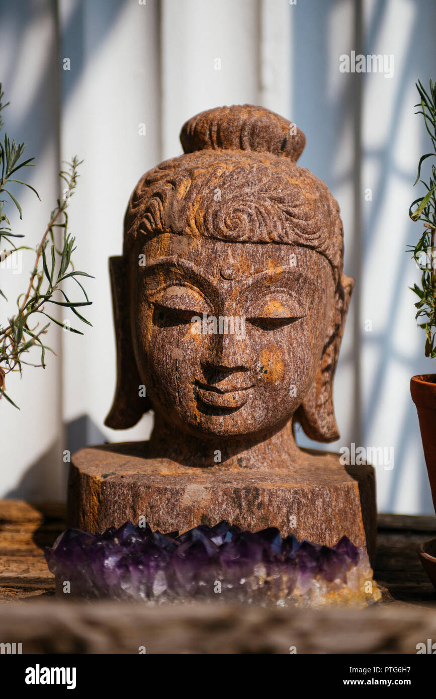 Stone Buddha bust with amethyst Stock Photo - Alamy