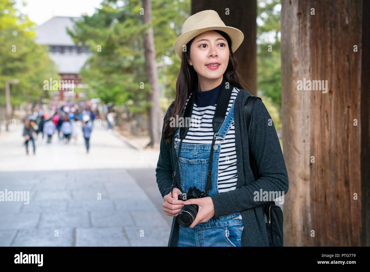 a beautiful female tourist seeing the view, holding the camera and ...