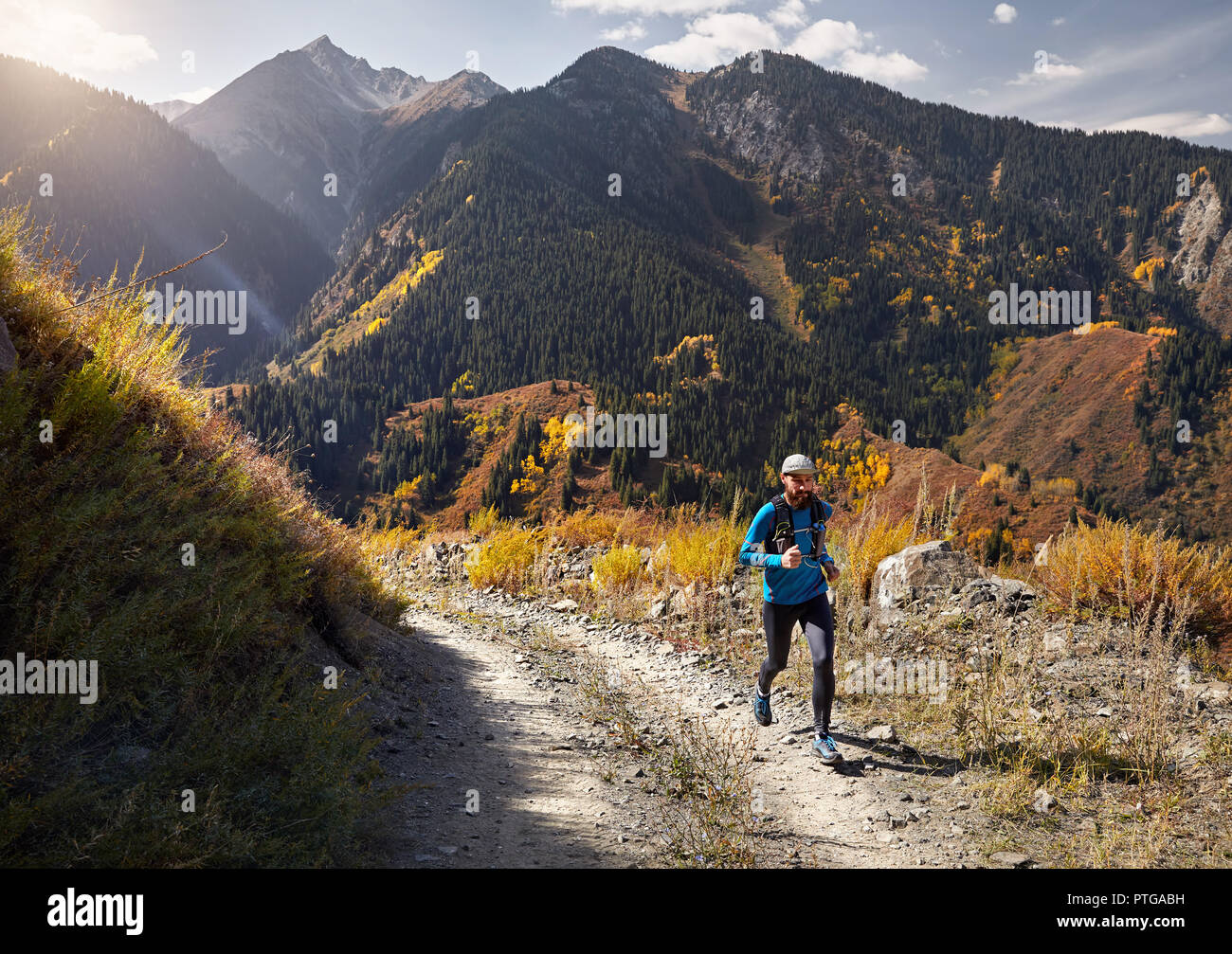 Runner athlete with beard running on the trail in the mountains Stock ...