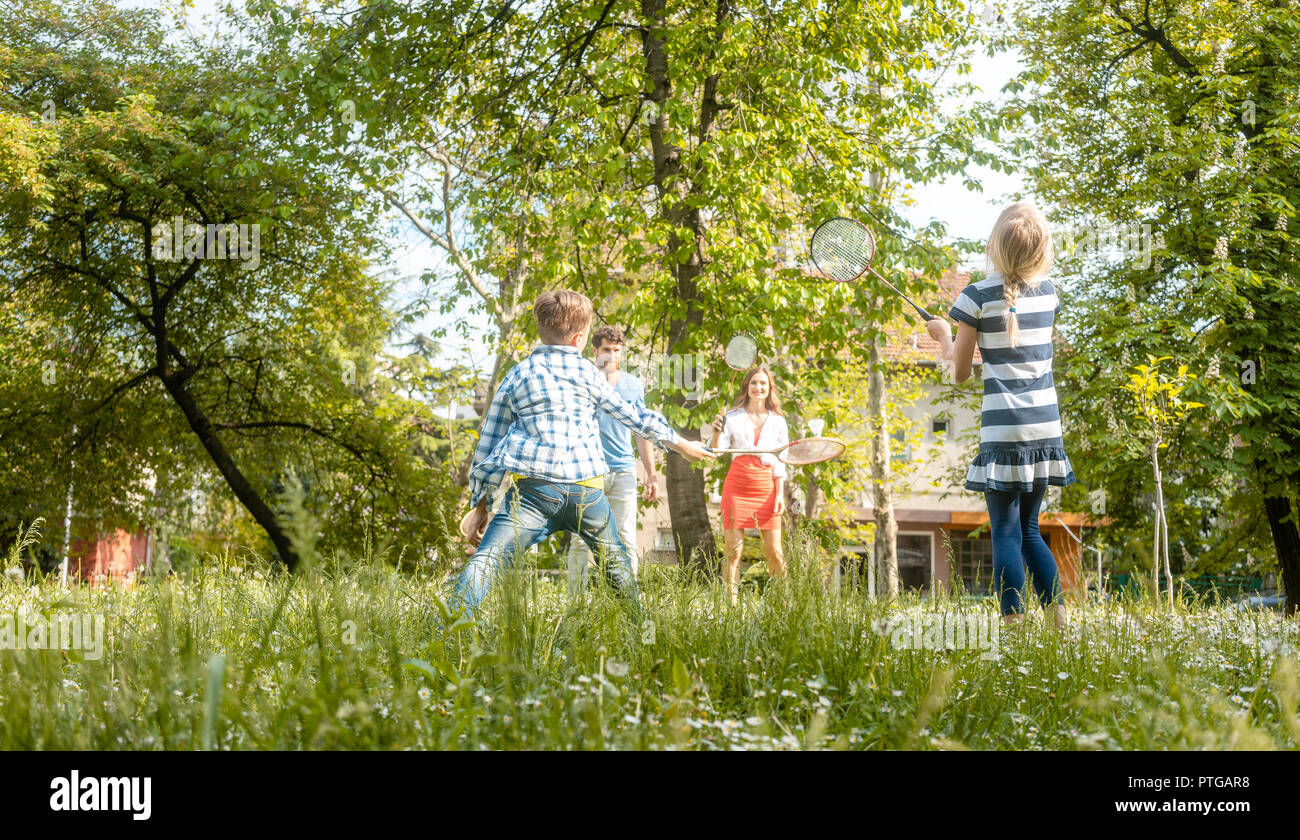 Family playing badminton on a meadow in summer having fun enjoying ...