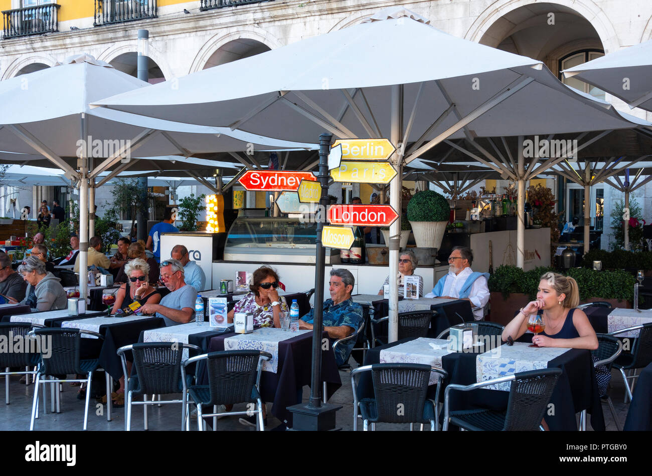 Directional street signs for cities of the world in front of a cafe in ...