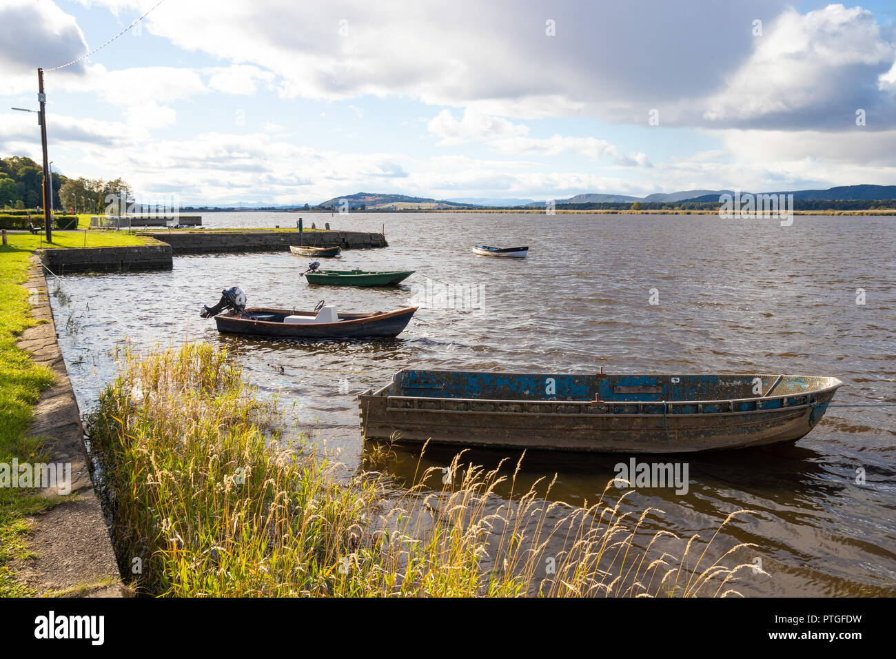 Fishing boats tied up at low tide on the banks of the River Tay at ...