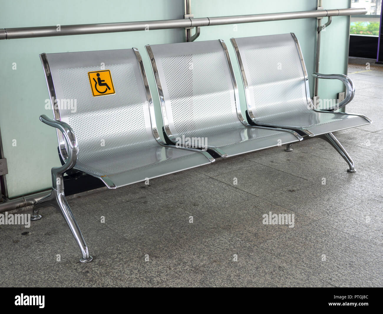 Stainless steel chairs in the train station with disabled signage to ...