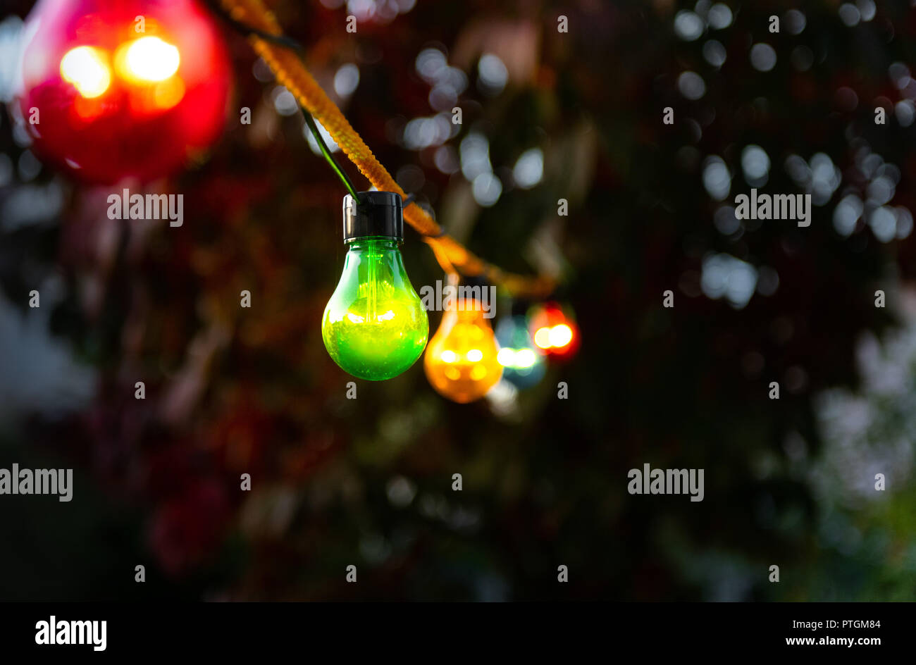 Red party light bulb shining on chain Stock Photo - Alamy