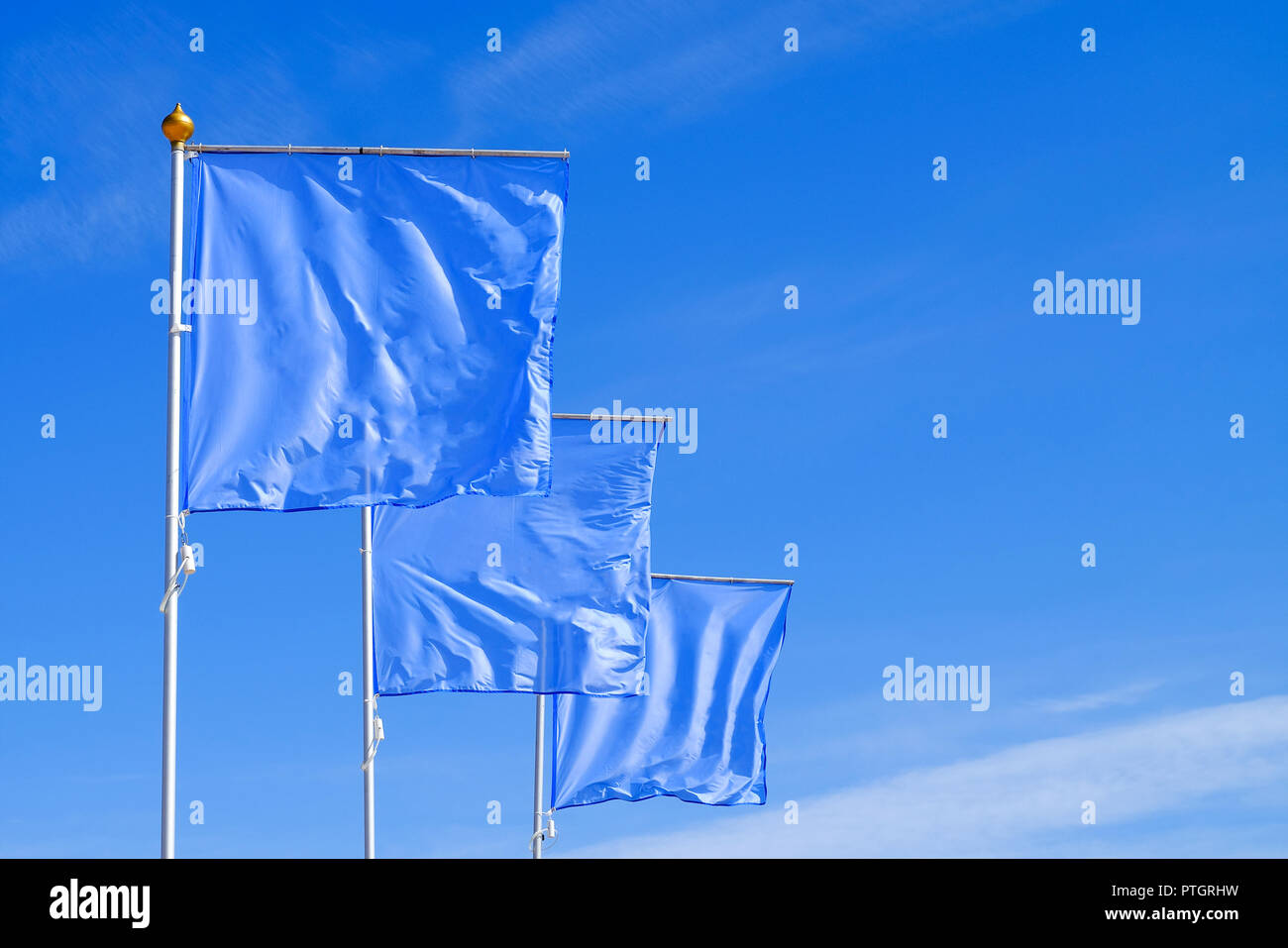 Blue flags waving in the wind against the cloudless sky. Perfect layout ...