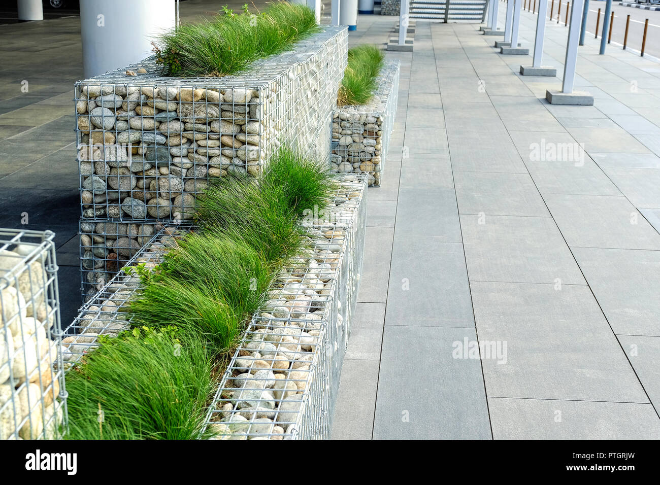 Stone walls in a metal grid. The design of the Mall Parking lot Stock ...