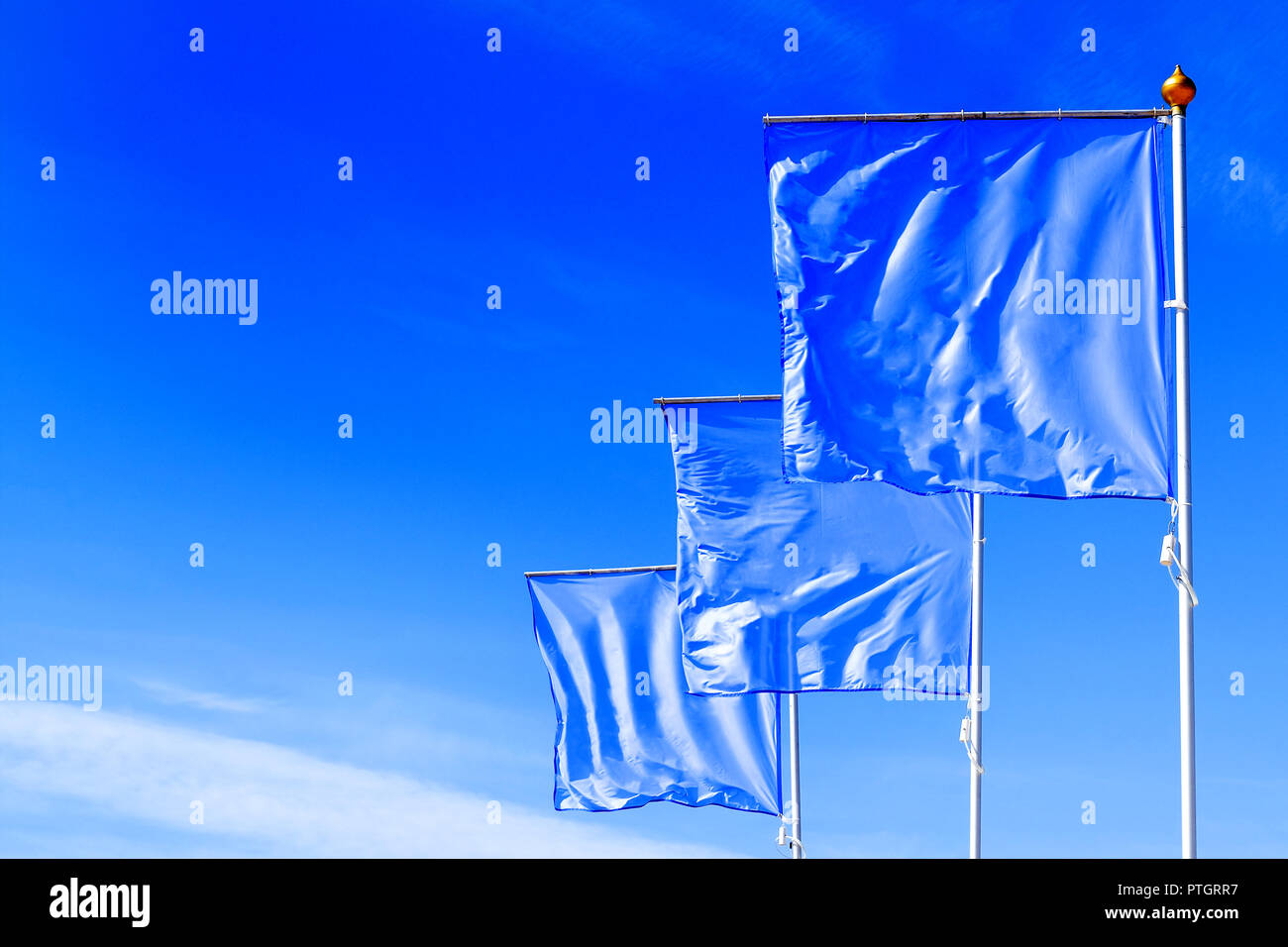 Blue flags waving in the wind against the cloudless sky. Perfect layout ...