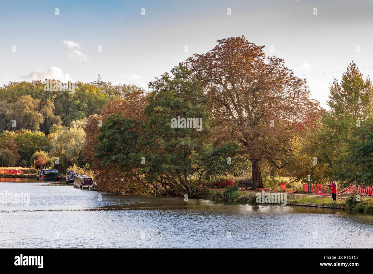 An angler near Iffley Lock on the River Thames dressed in red that ...