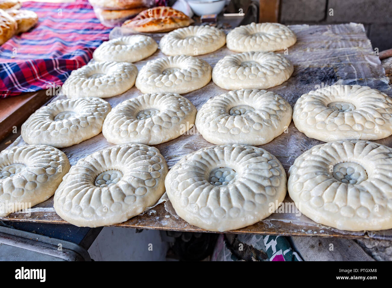 Traditional uzbek round flatbread is preparing to put in the tandyr ...