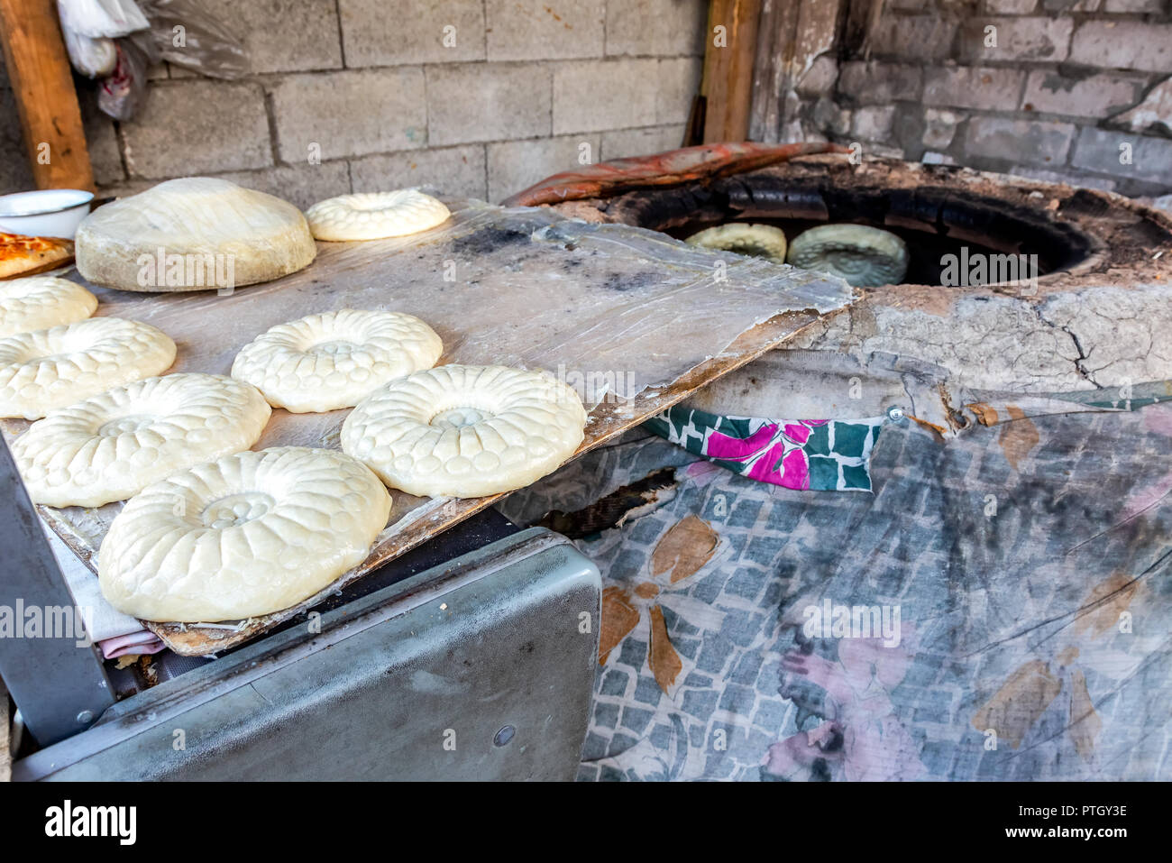 Traditional uzbek round flatbread is preparing to put in the tandyr ...