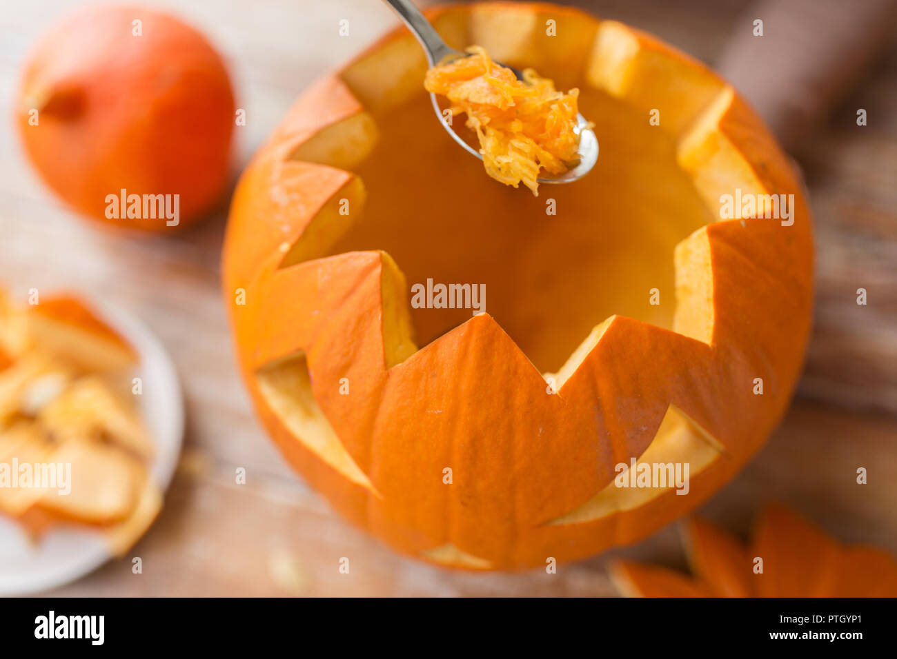 close up of spoon carving halloween pumpkin Stock Photo - Alamy