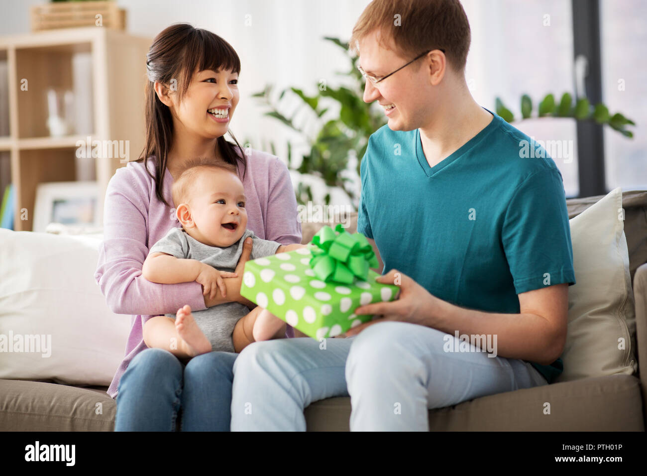 mother with baby giving birthday present to father Stock Photo - Alamy