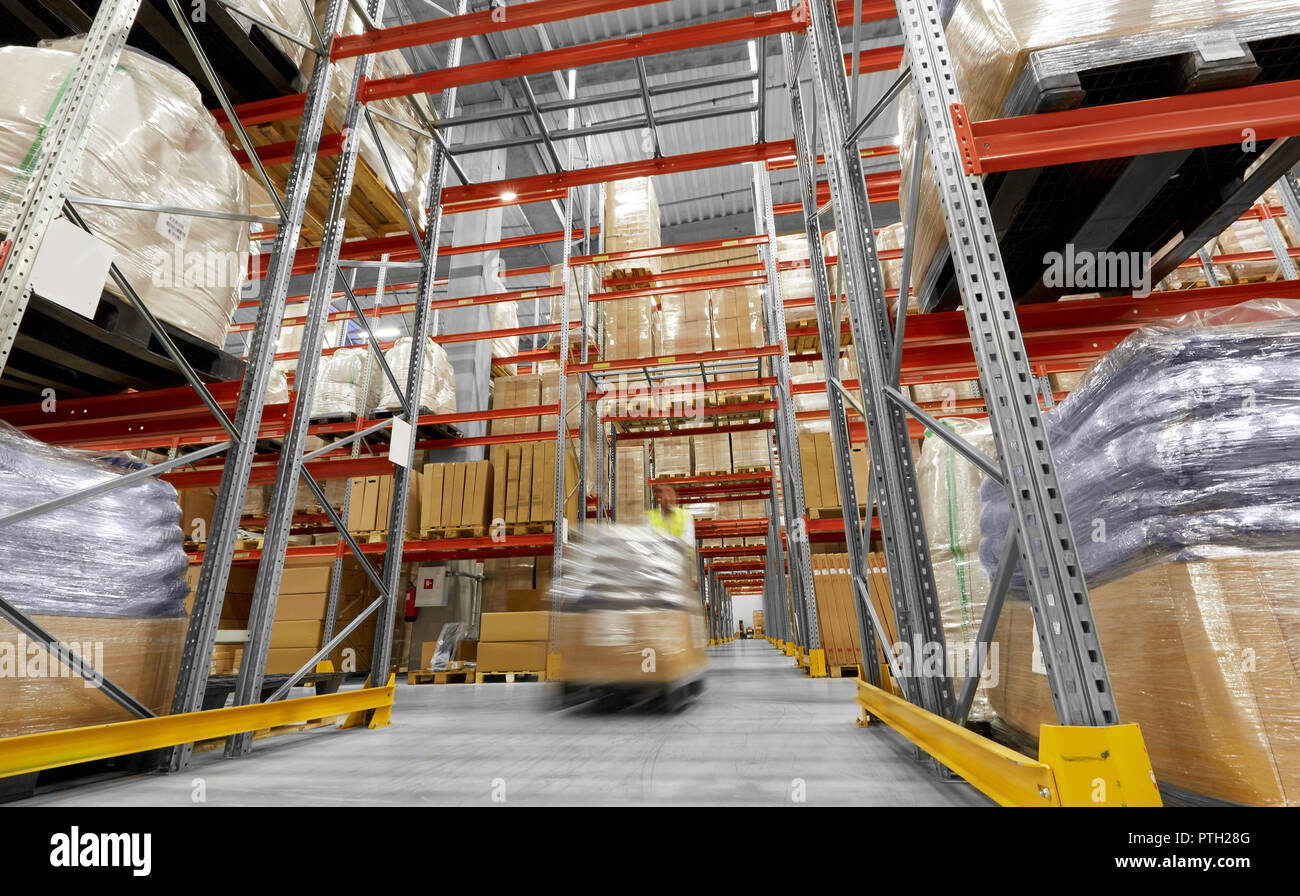 worker carrying loader with goods at warehouse Stock Photo - Alamy