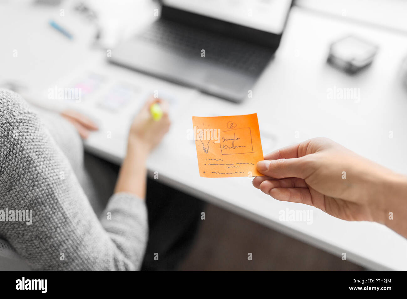 hand of designer holding sticky note with idea Stock Photo - Alamy