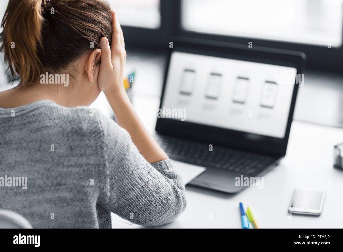 stressed designer with user interface on laptop Stock Photo - Alamy