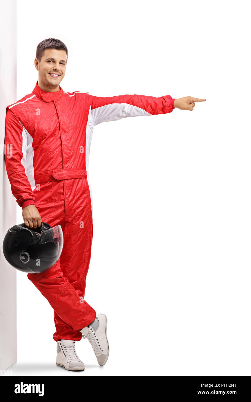 Full length portrait of a racer leaning on a wall and pointing isolated ...