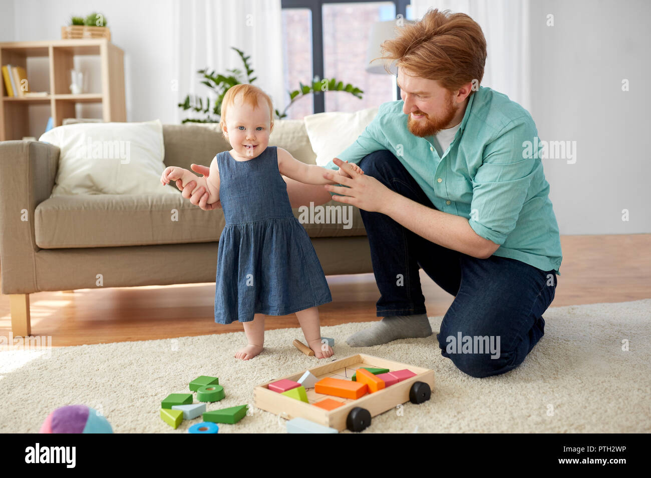 baby girl standing with father help at home Stock Photo - Alamy