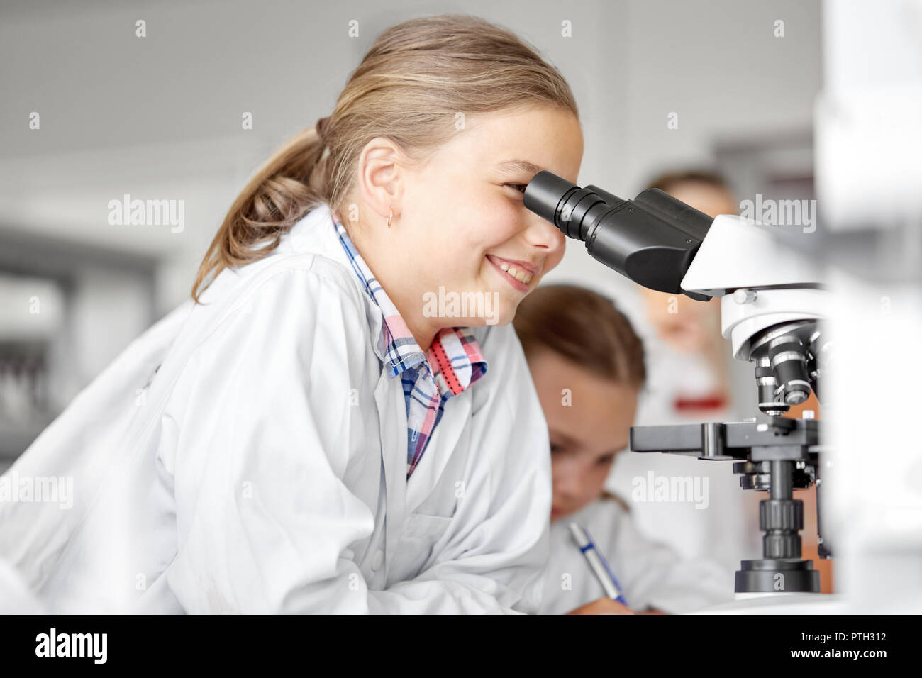 kids or students with microscope biology at school Stock Photo - Alamy
