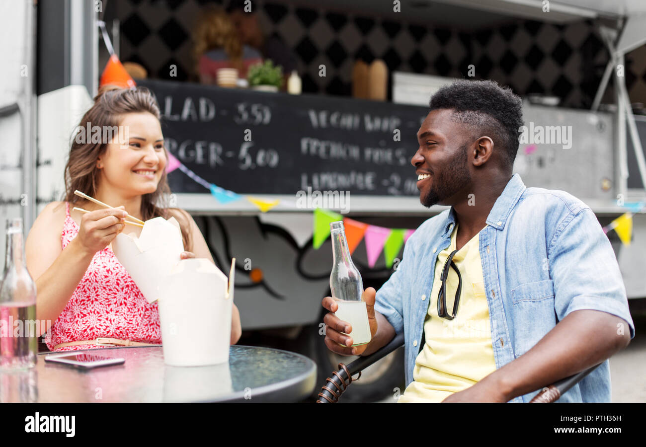 mixed race couple eating and talking at food truck Stock Photo - Alamy