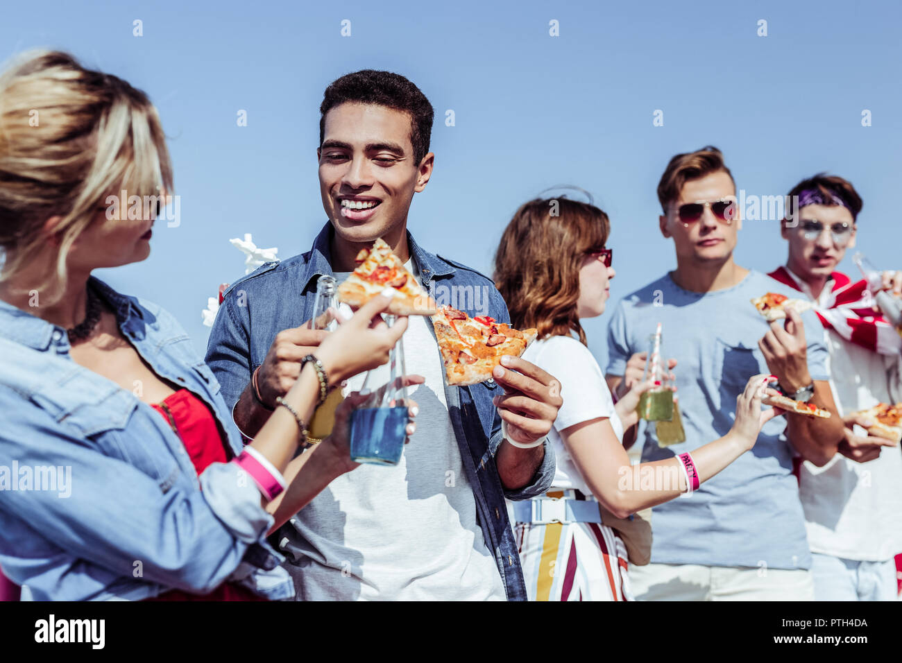 Positive delighted people eating pizza on rooftop Stock Photo - Alamy