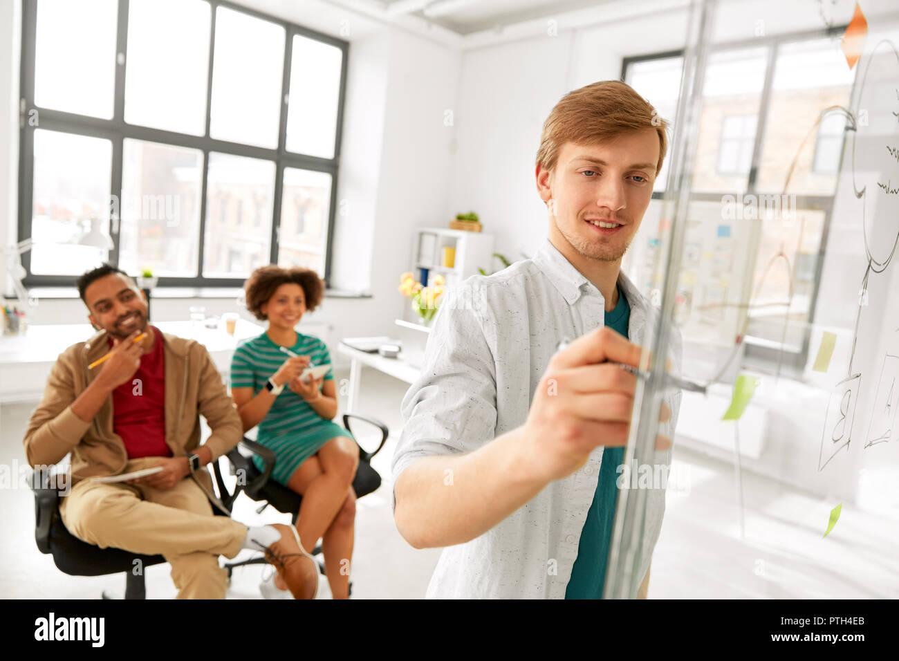 man drawing scheme for creative team at office Stock Photo - Alamy
