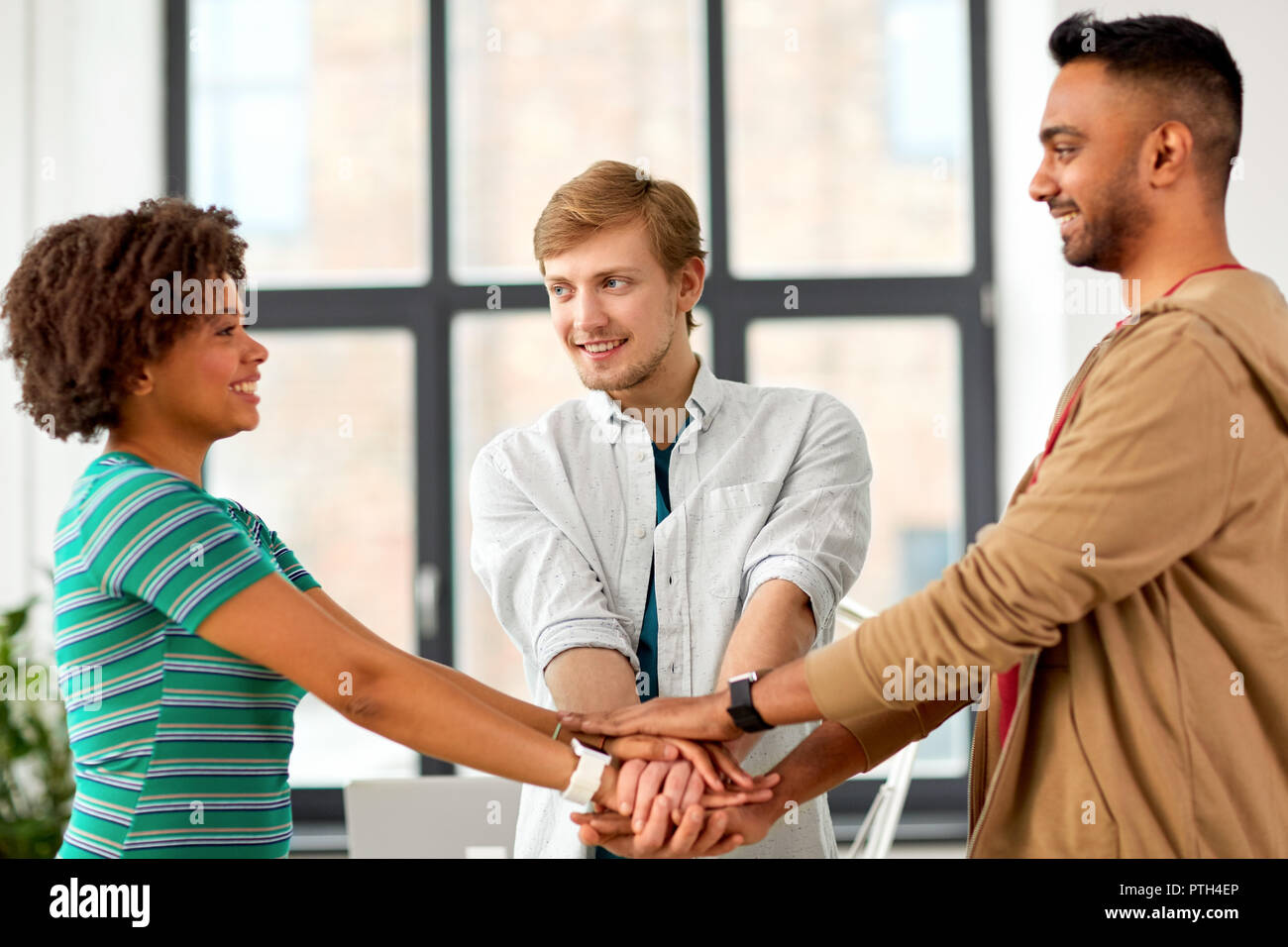 happy creative team stacking hands at office Stock Photo - Alamy