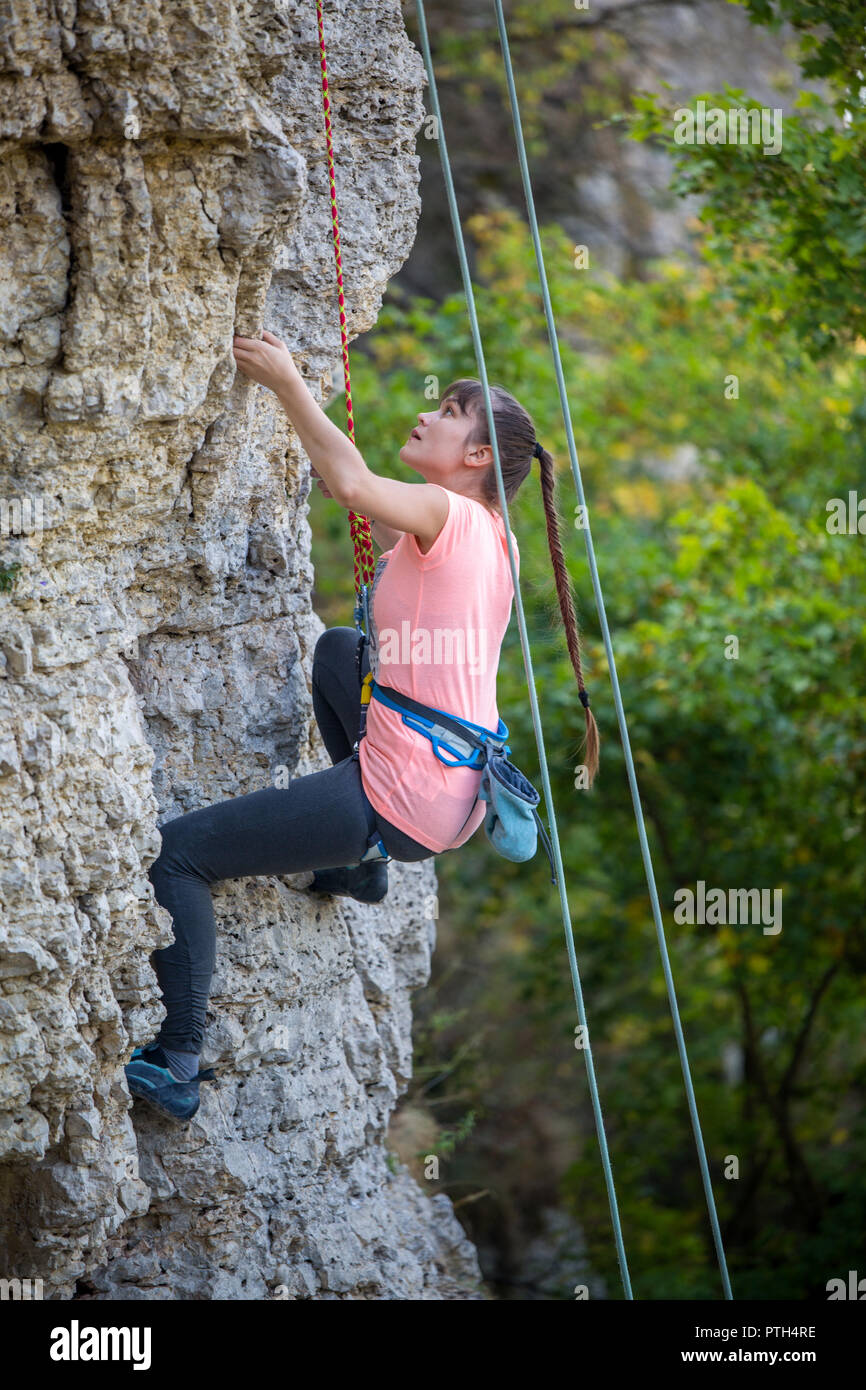 Photo of athlete girl clambering over rock Stock Photo - Alamy