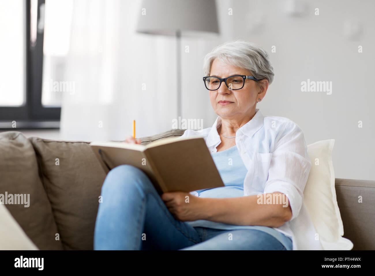 senior woman writing to notebook or diary at home Stock Photo - Alamy