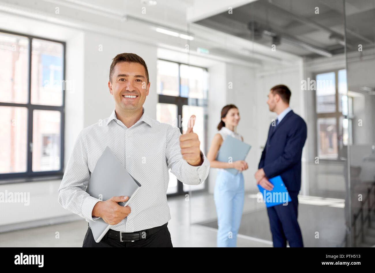 realtor with folder showing thumbs up at office Stock Photo - Alamy