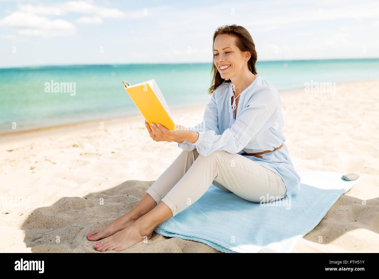 Person reading book on beach hi-res stock photography and images - Alamy