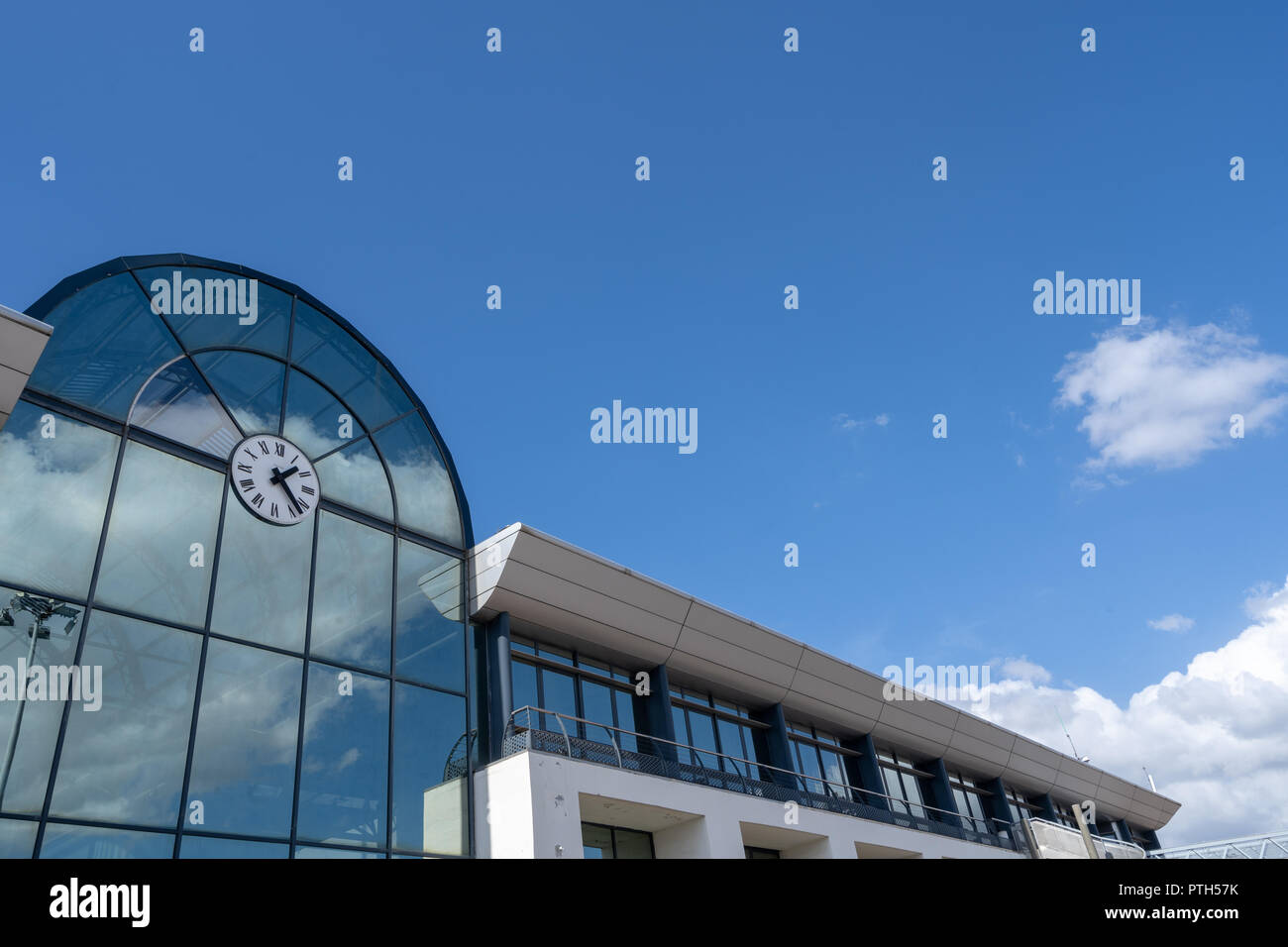 Building with glass facade and a clock Stock Photo - Alamy
