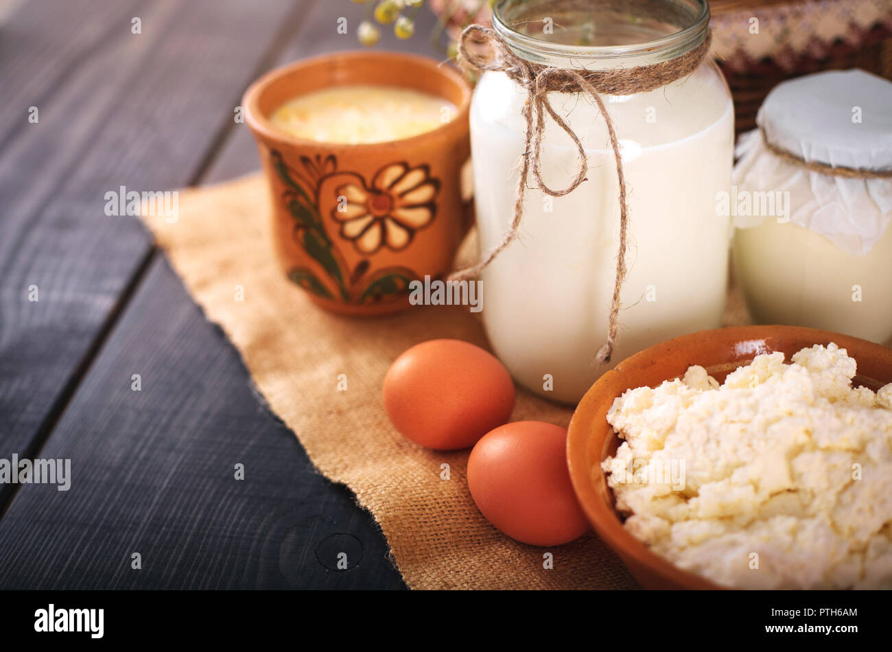A can of milk and other farm products on the table. Still life in rural ...