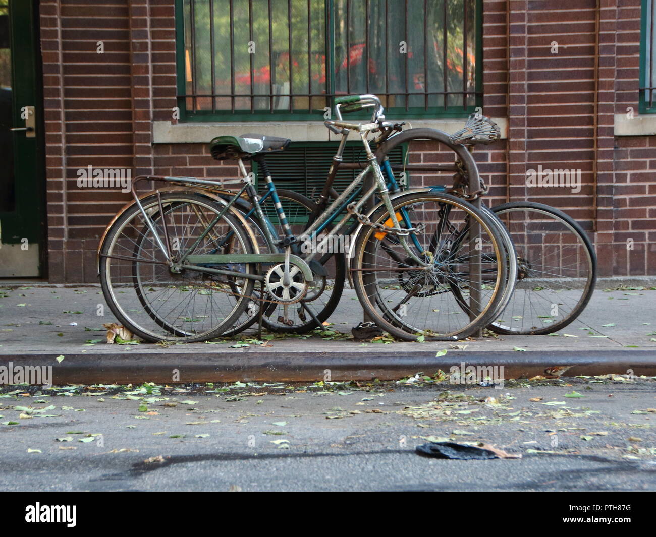 Three Worn Parked Bicycles on Concrete Urban Pavement in New York ...