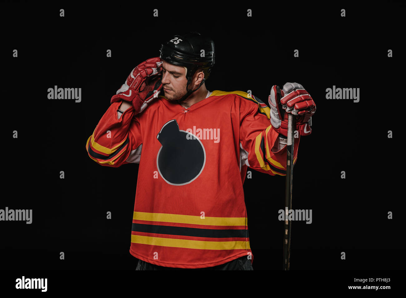tired hockey player standing with hockey stick isolated on black Stock ...