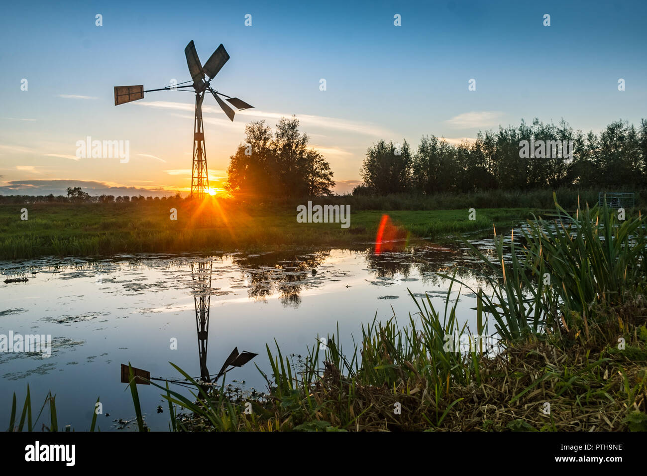 Dutch Windmill Silhouette Against the Setting Sun Stock Photo - Alamy