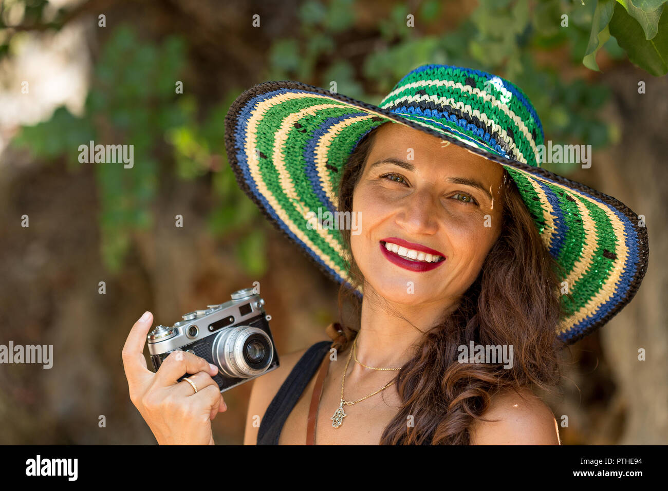 Head and shoulders portrait of smiling traveller female wearing striped ...